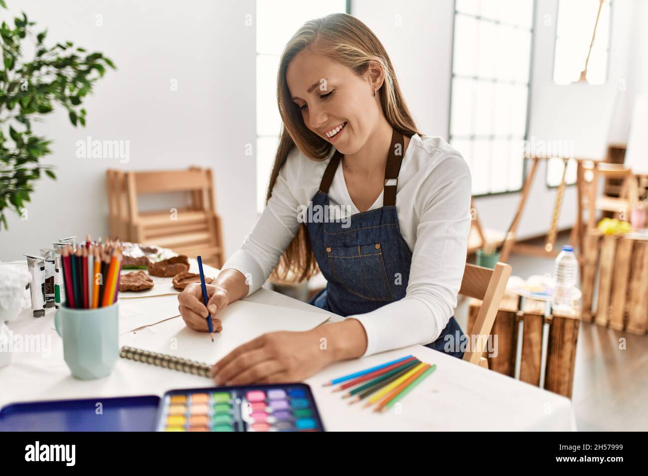 Young caucasian woman smiling confident drawing on notebook at art ...