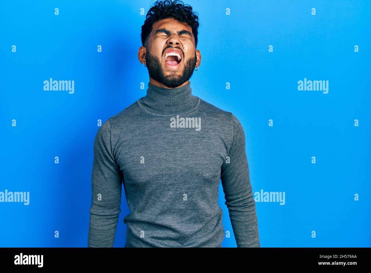 Arab man with beard wearing turtleneck sweater angry and mad screaming ...