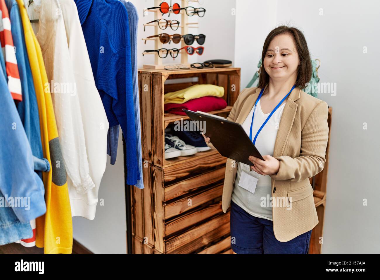 Brunette woman with down syndrome working as shop manager checking ...