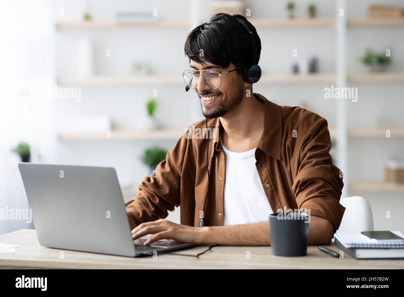 Happy indian guy attending webinar, typing on laptop keyboard Stock ...
