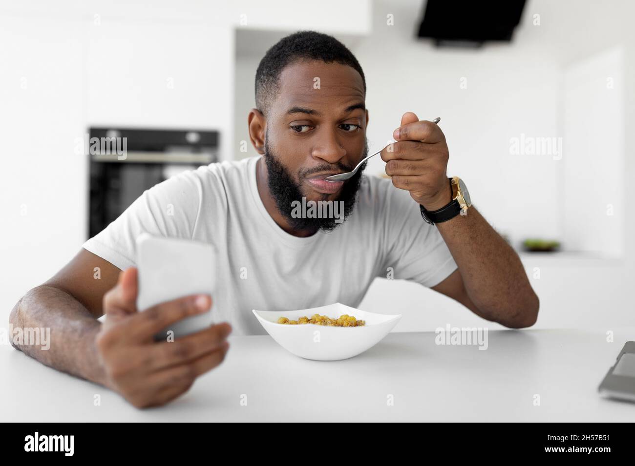 Black man rushing to work eating cereal at home Stock Photo - Alamy