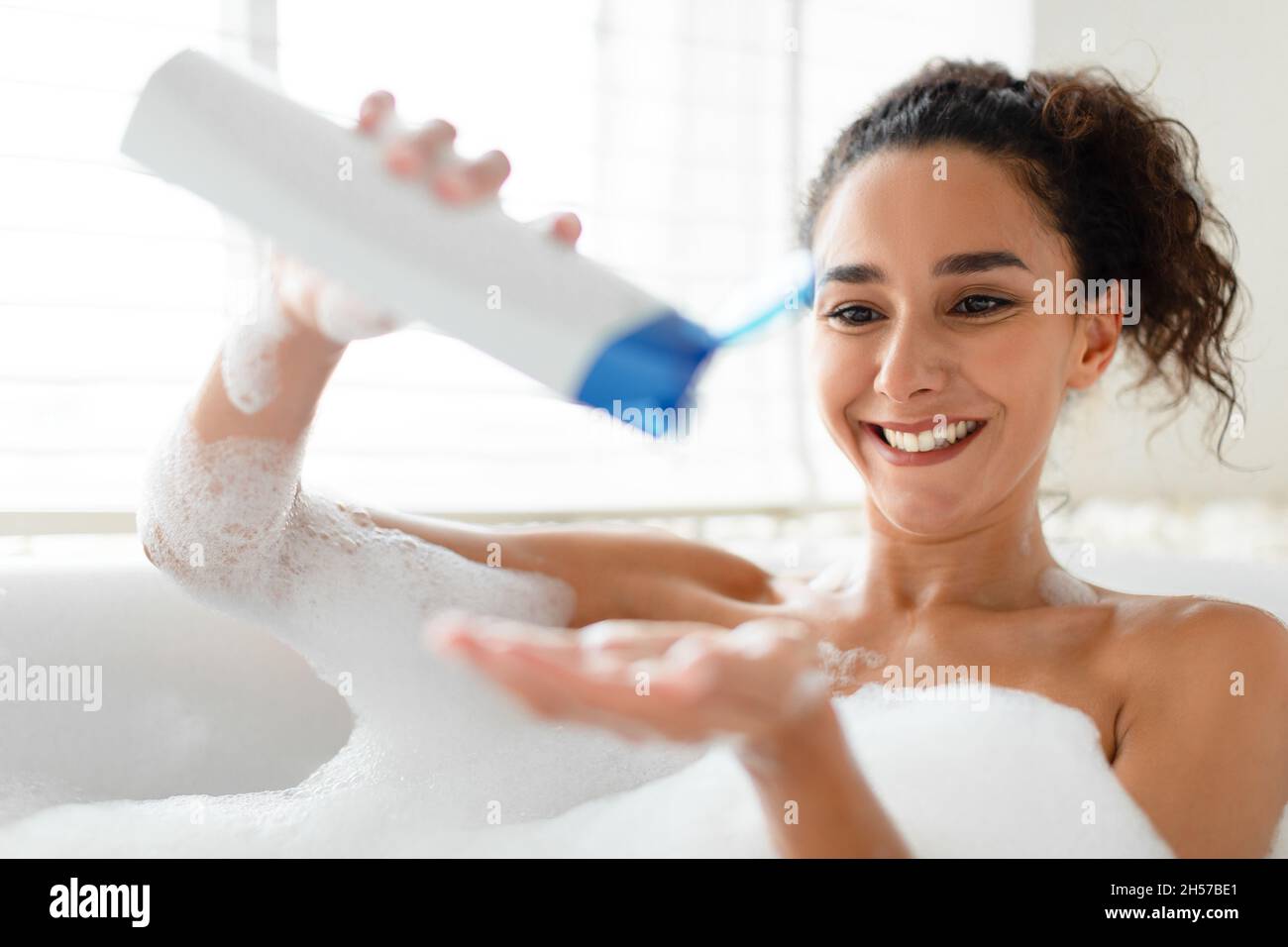 Beautiful Young Woman Lying In Warm Bath Using Shampoo Or Foam At Home