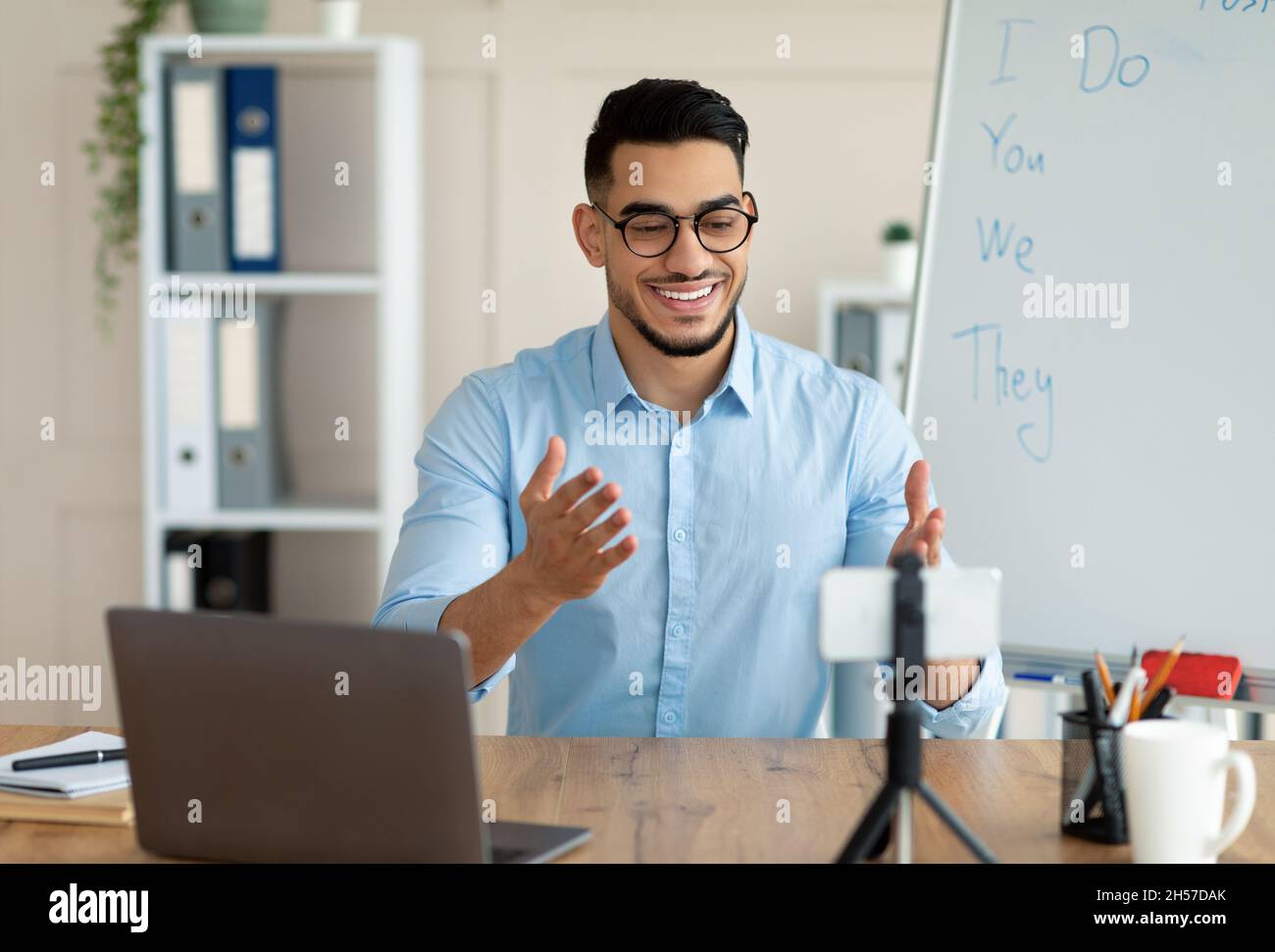 Remote learning concept. Joyful Arab teacher giving online English ...