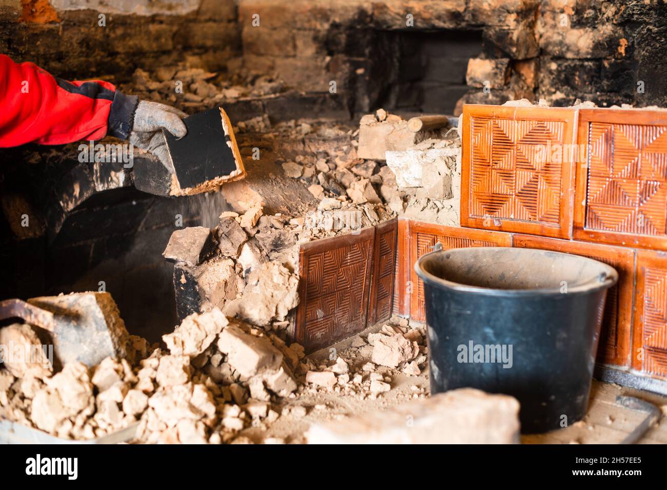 An old brick stove, brick in soot, dismantling the old kitchen with his ...