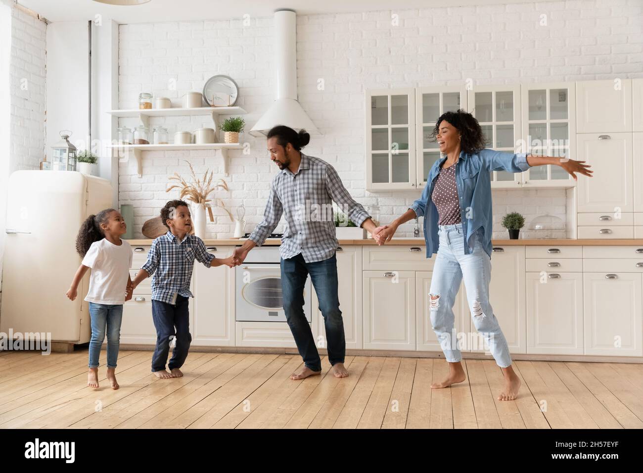 Excited African American family dancing to music in kitchen Stock Photo ...