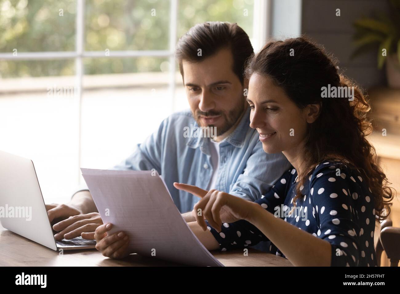 Young spouses hold bank account statement check financial data online ...