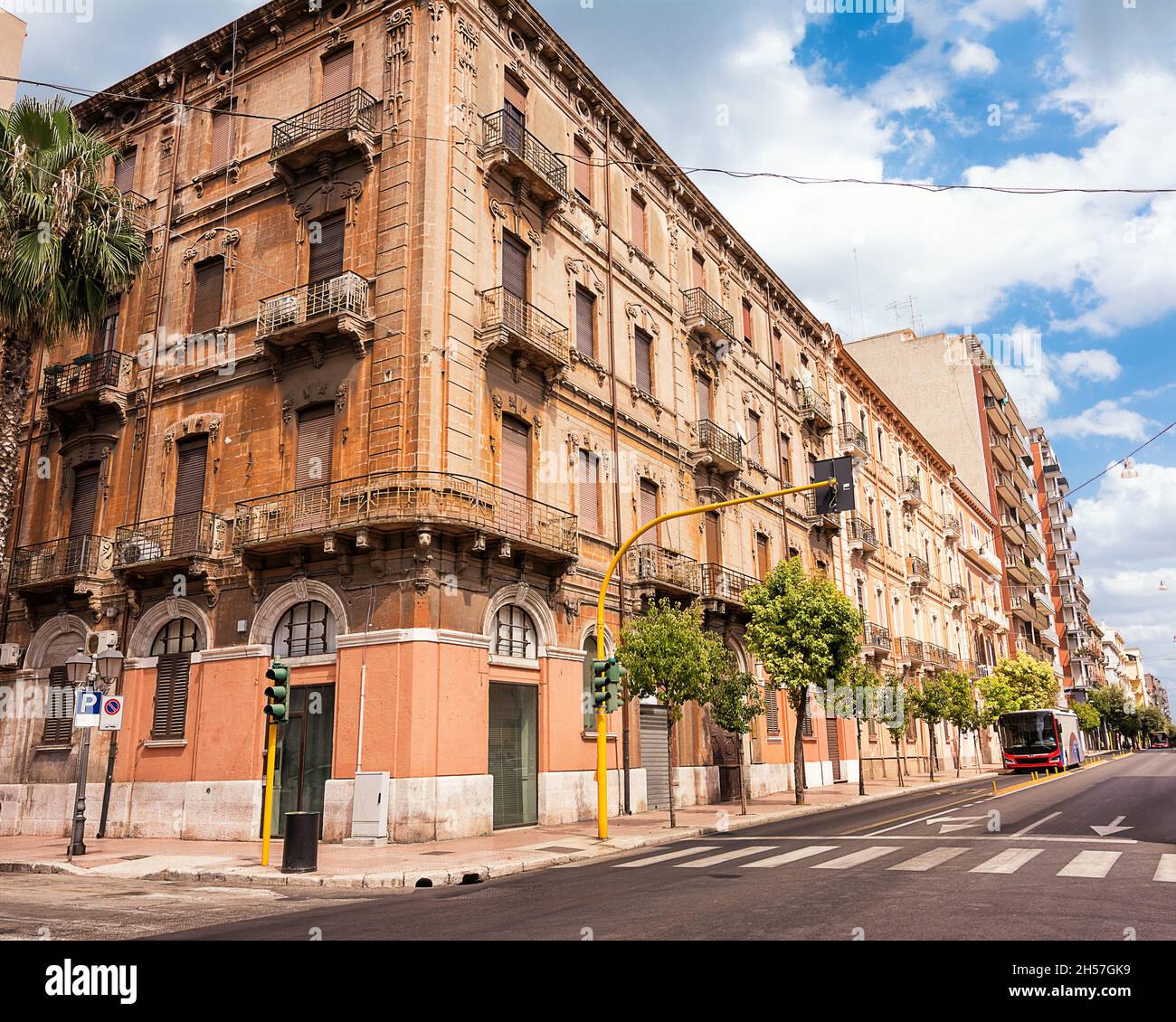 Corner of an ancient building in Taranto (Italy) and buses arriving on ...