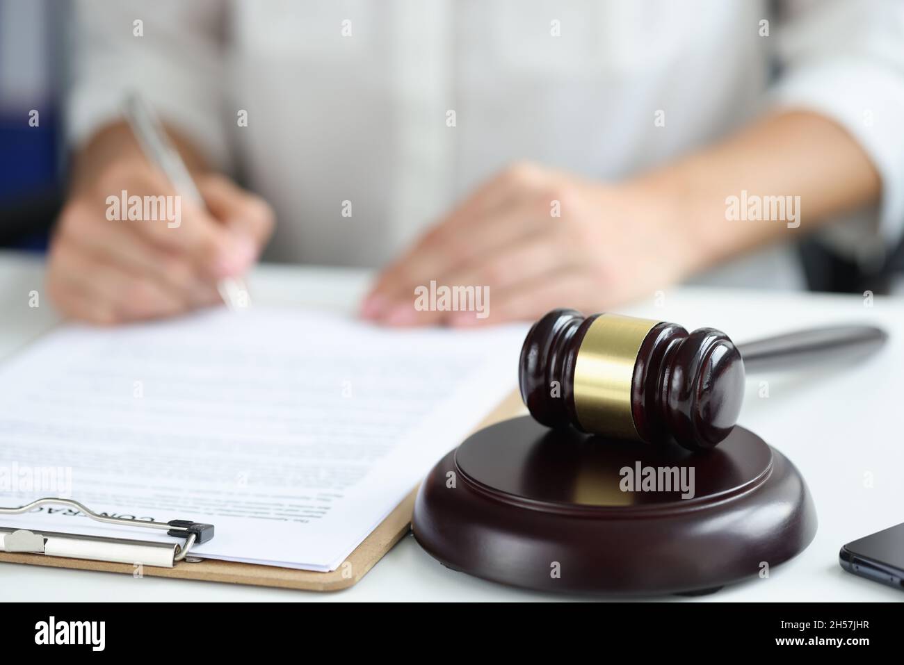 Judge signing document at table near wooden gavel closeup Stock Photo ...