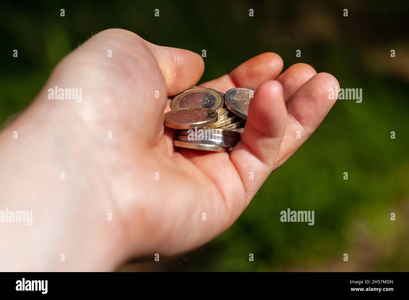 Giving money. Euro coins. Coins in hand Stock Photo - Alamy