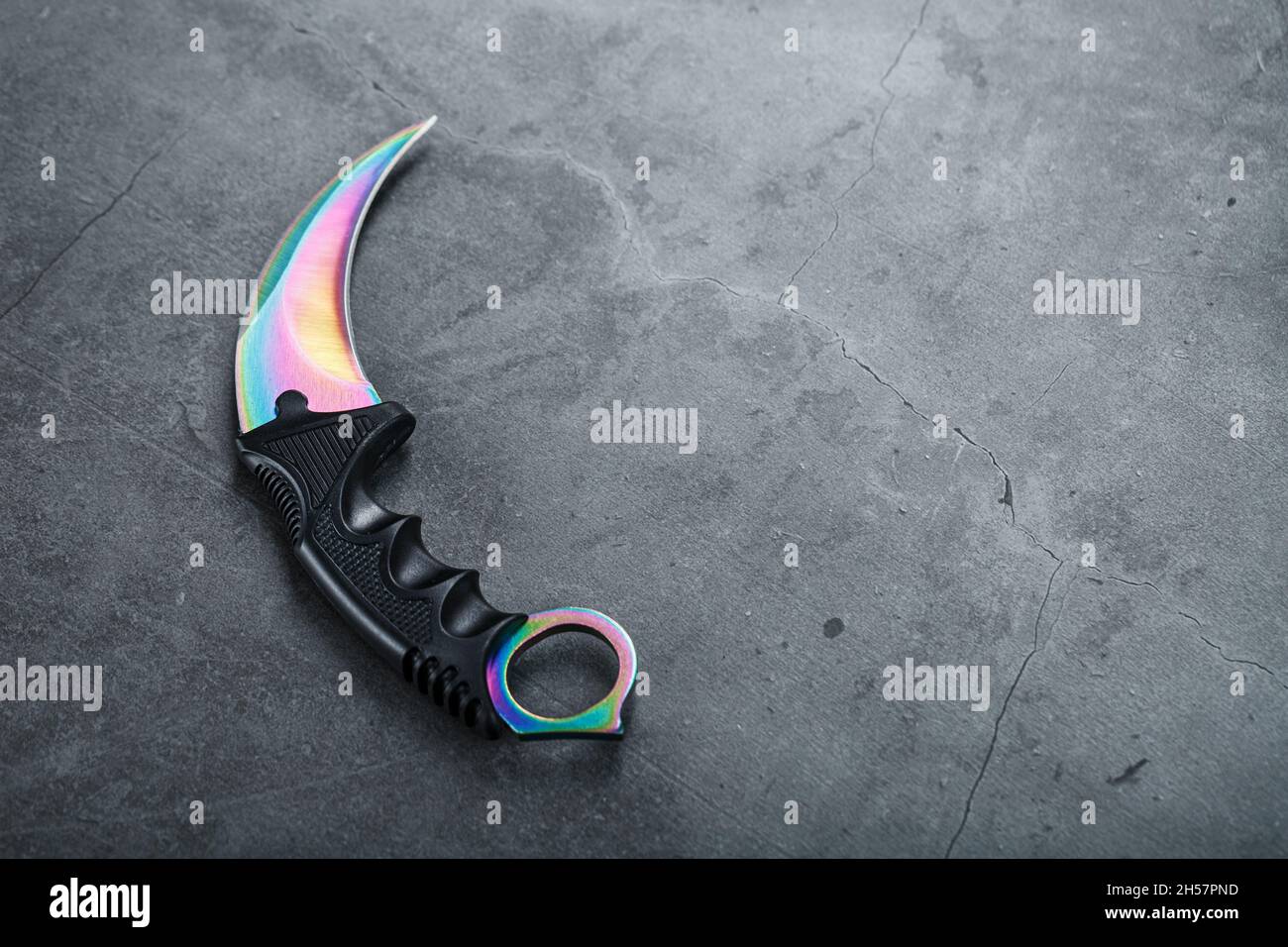 A dagger with a steel blade with a gradient color on a black background ...