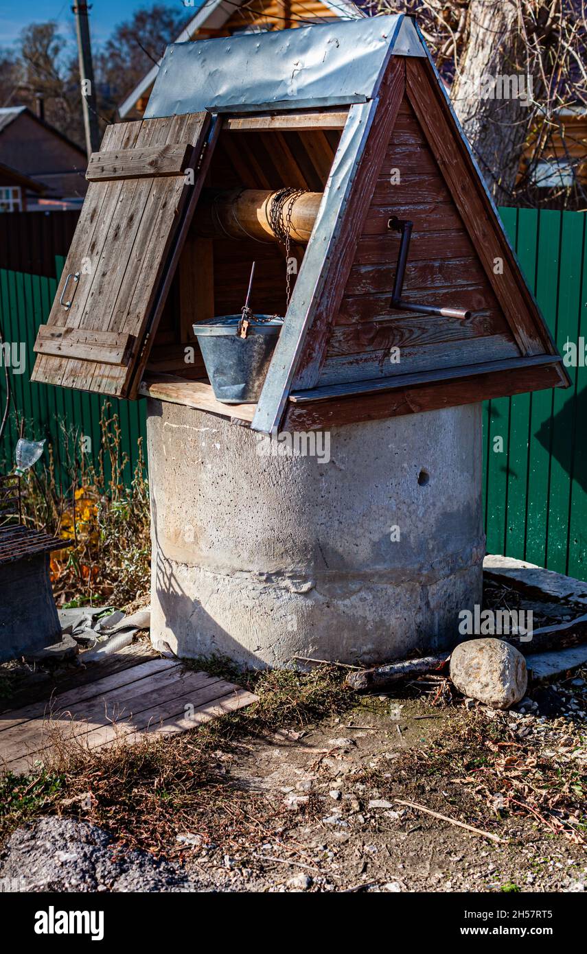 stone well with wooden roof with bucket Stock Photo - Alamy