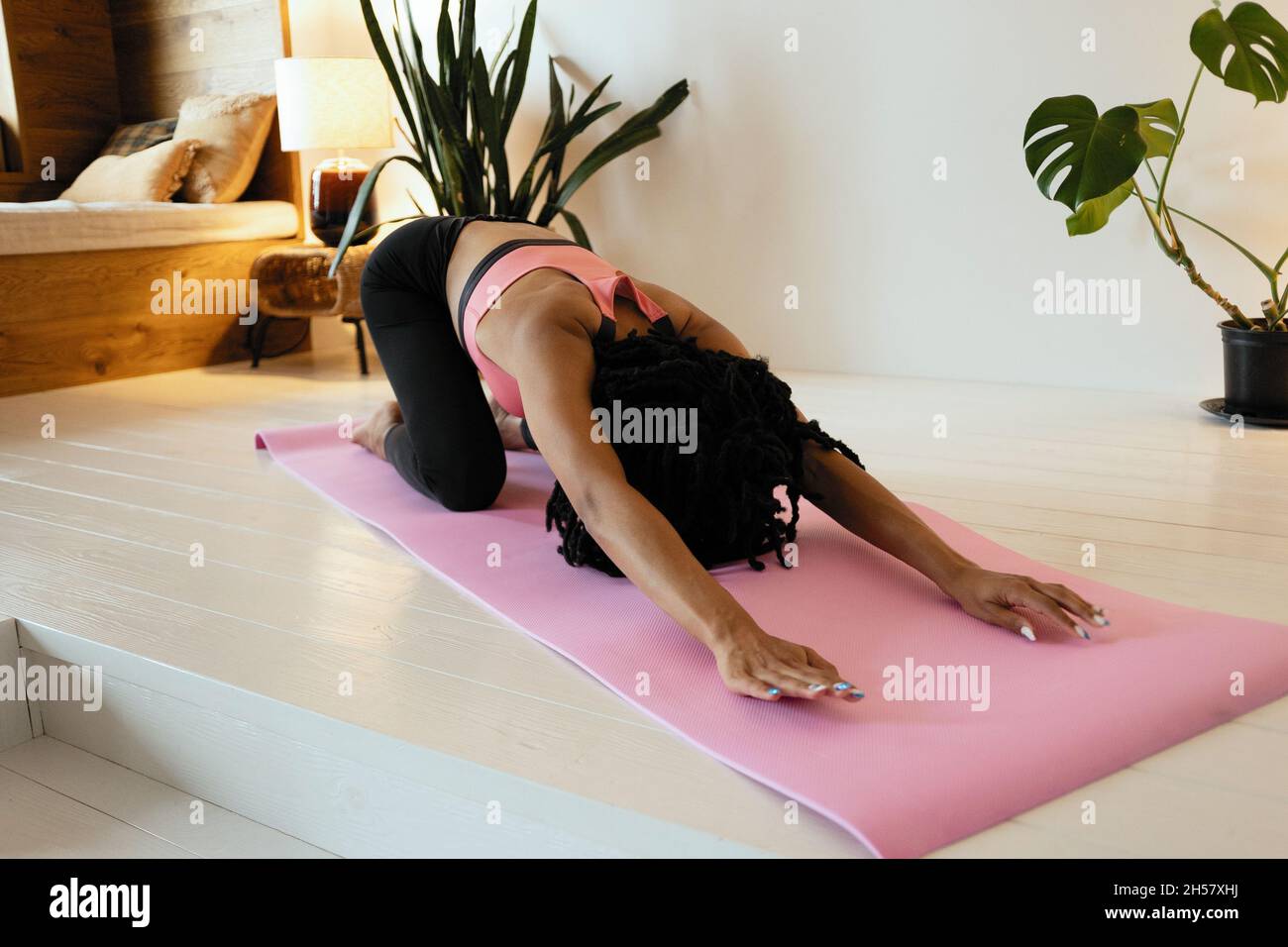 Time for yoga. Attractive and healthy young black woman doing exercises ...