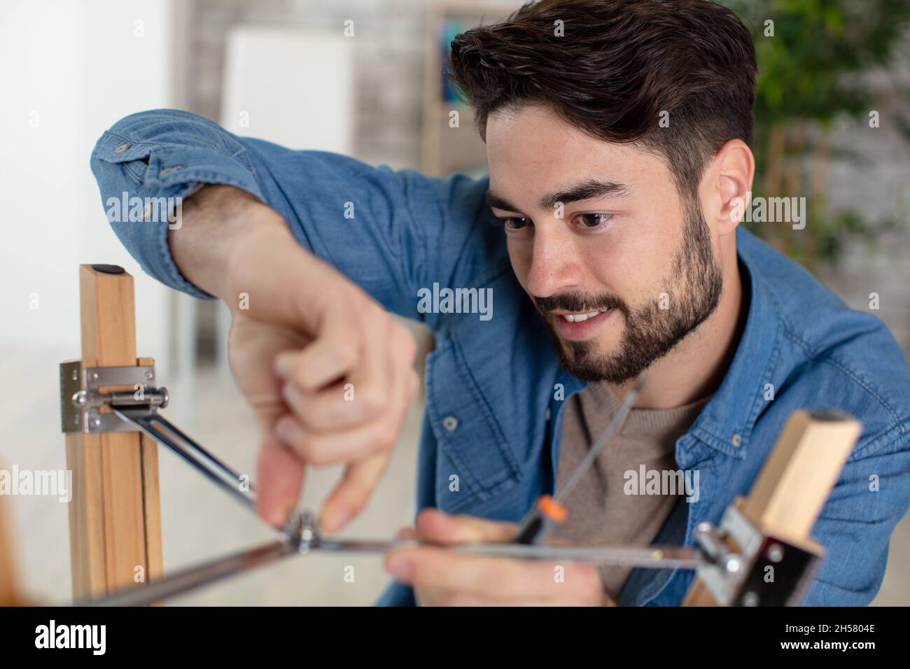 man putting together self assembly furniture in new home Stock Photo ...
