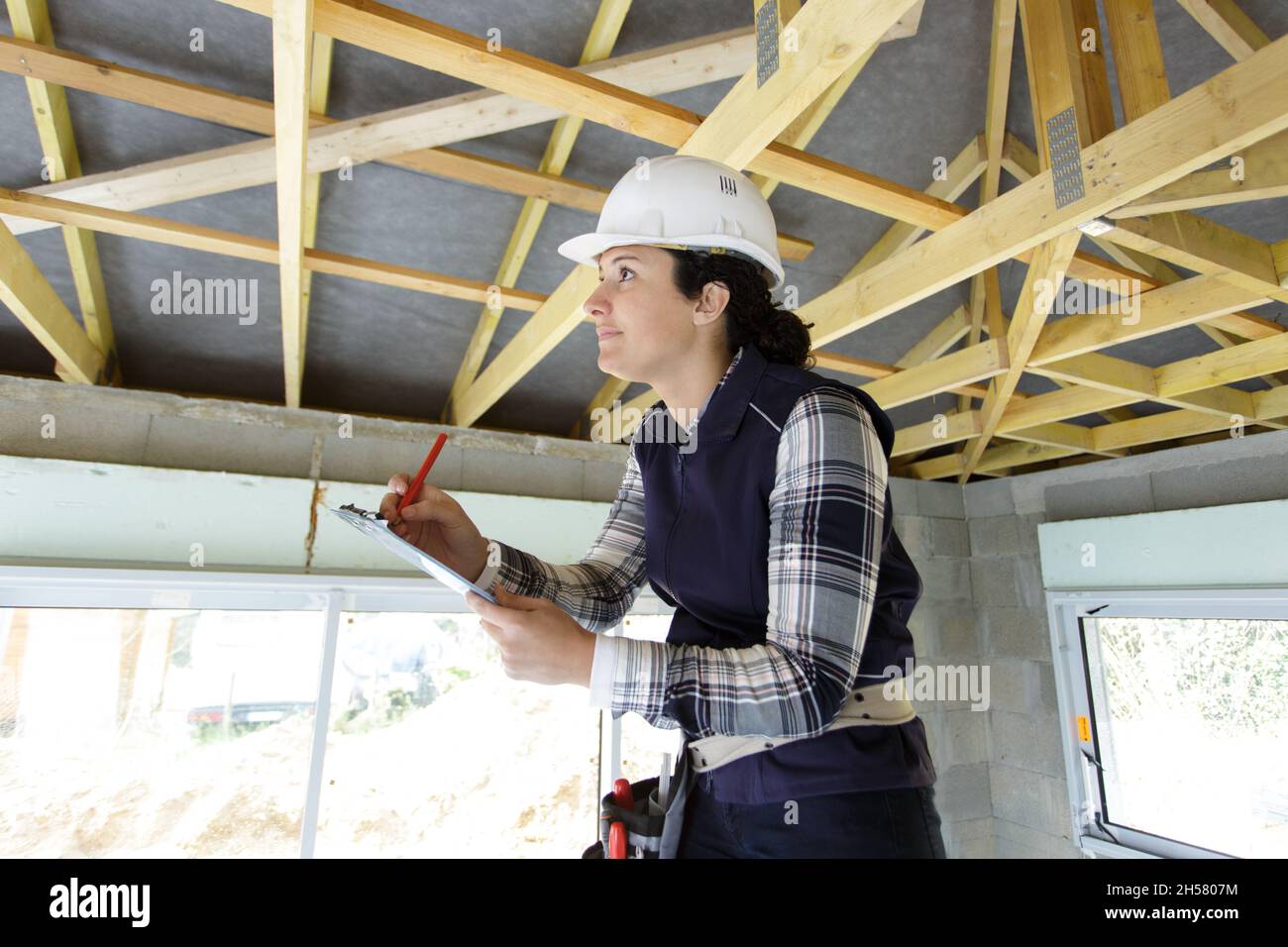 woman with clipboard inspecting roof of new building Stock Photo - Alamy