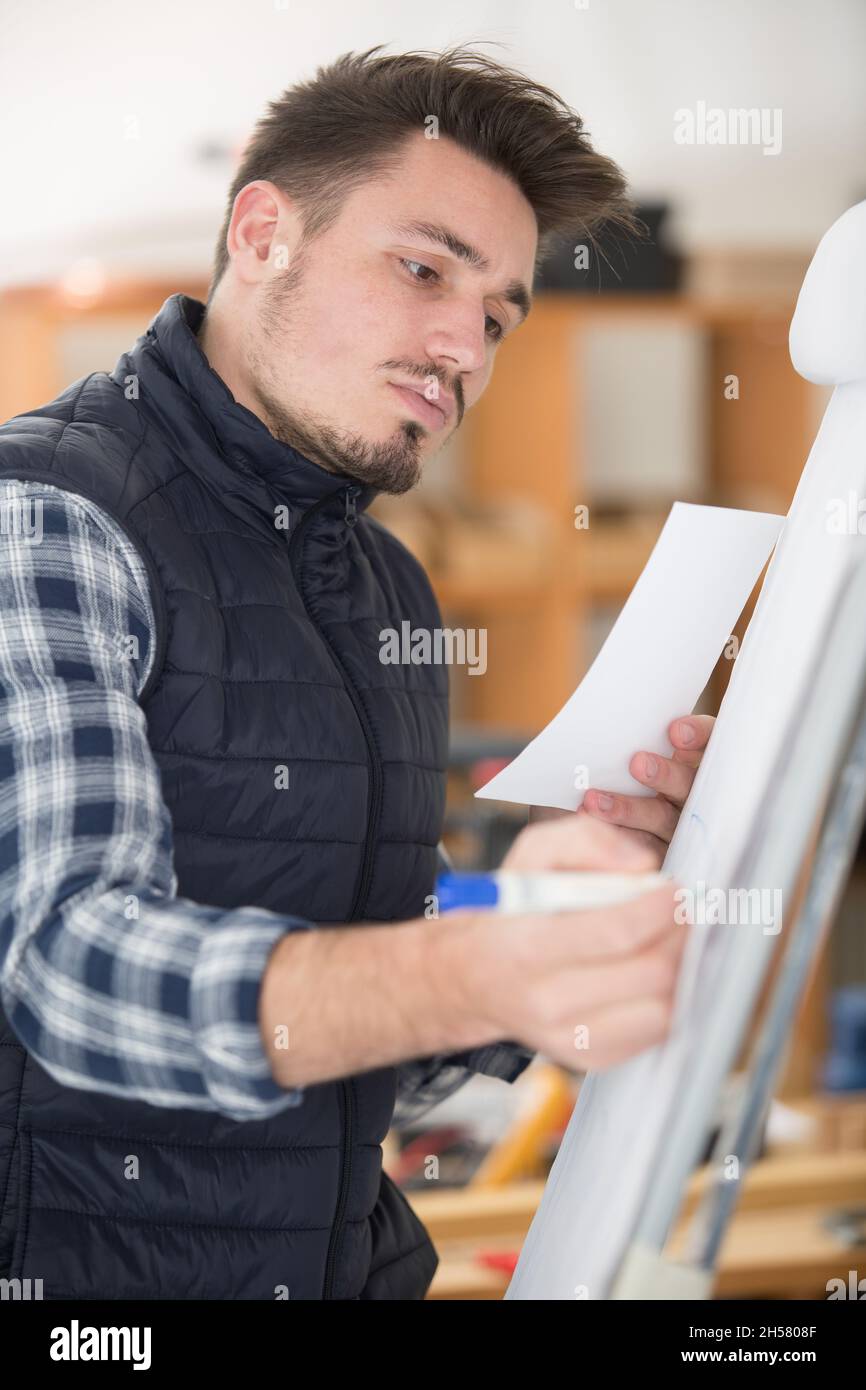 contemplative man drawing on flipchart Stock Photo - Alamy