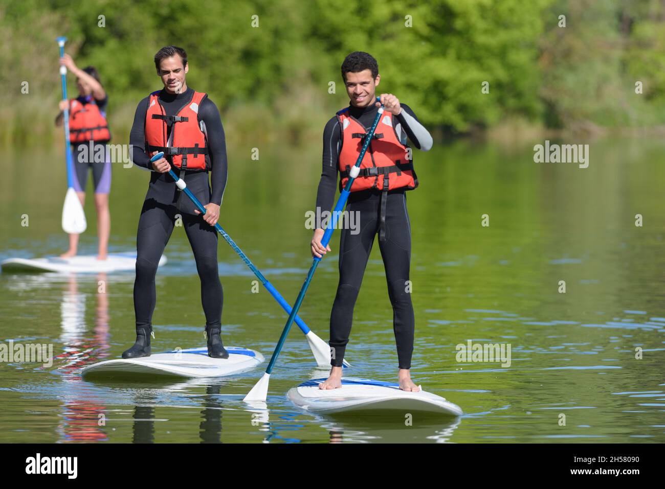 3 men on standing paddleboard Stock Photo - Alamy