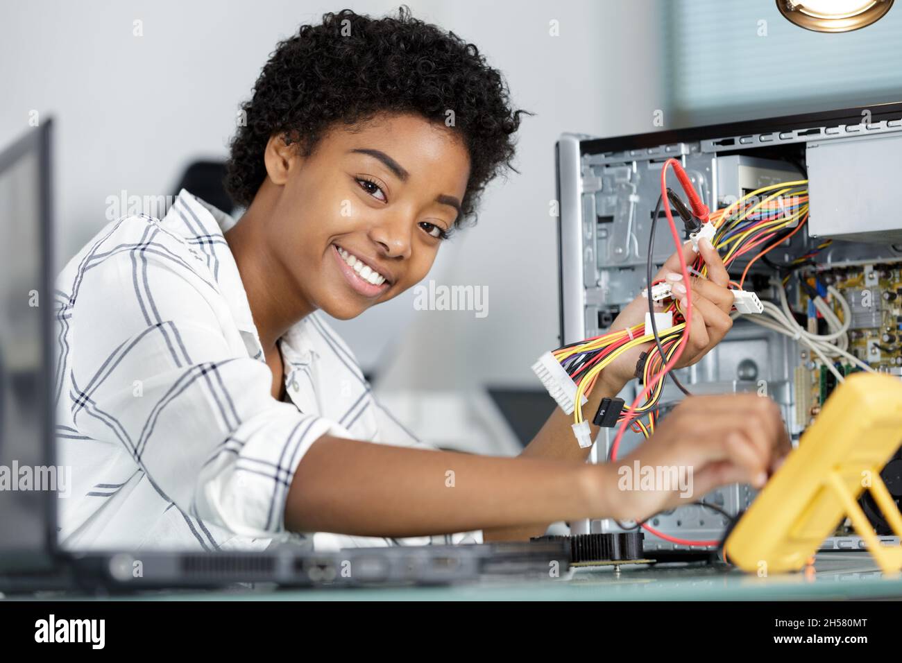 happy young female pc technician looking at camera Stock Photo - Alamy