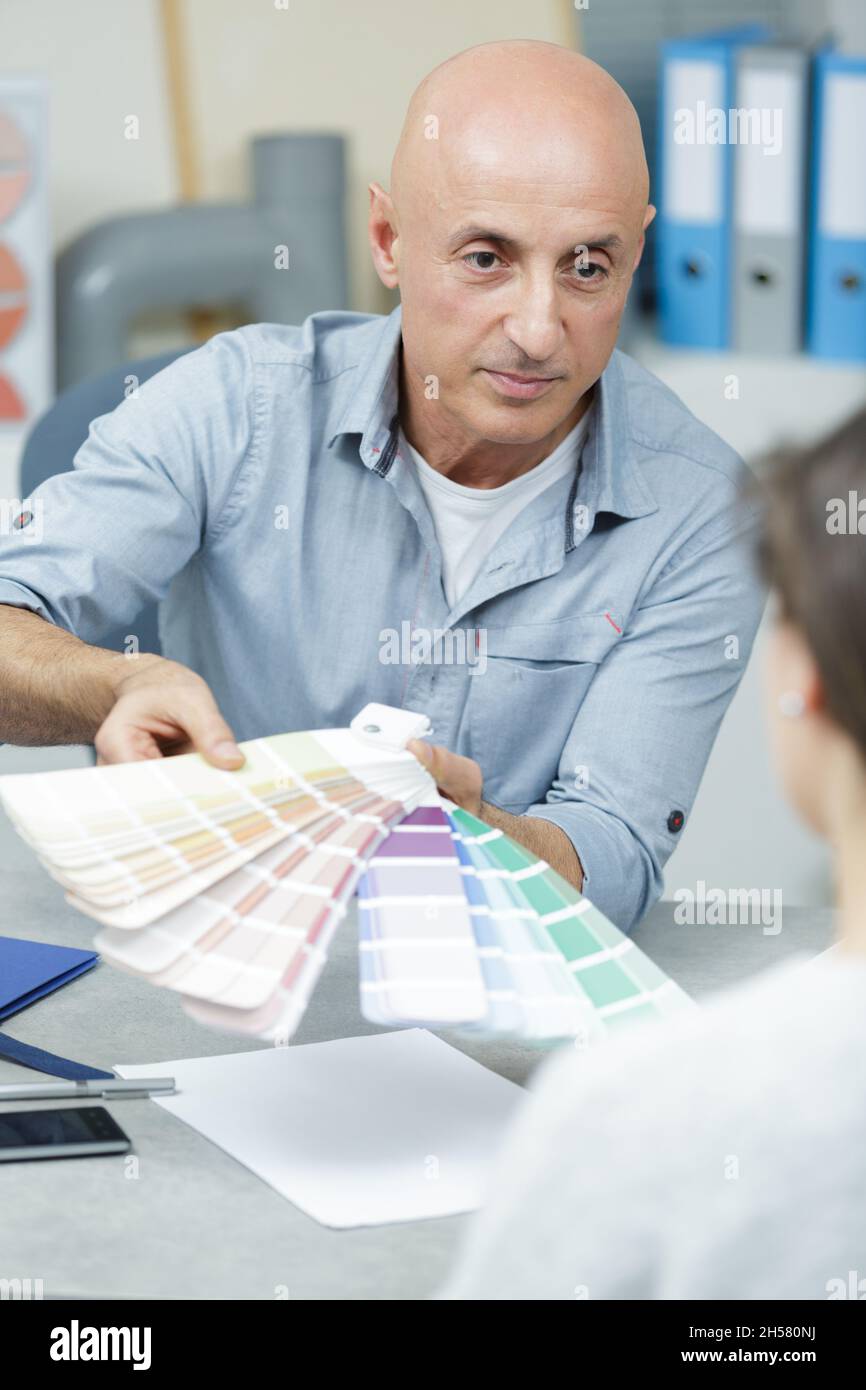 interior designer showing customer colour choice Stock Photo - Alamy
