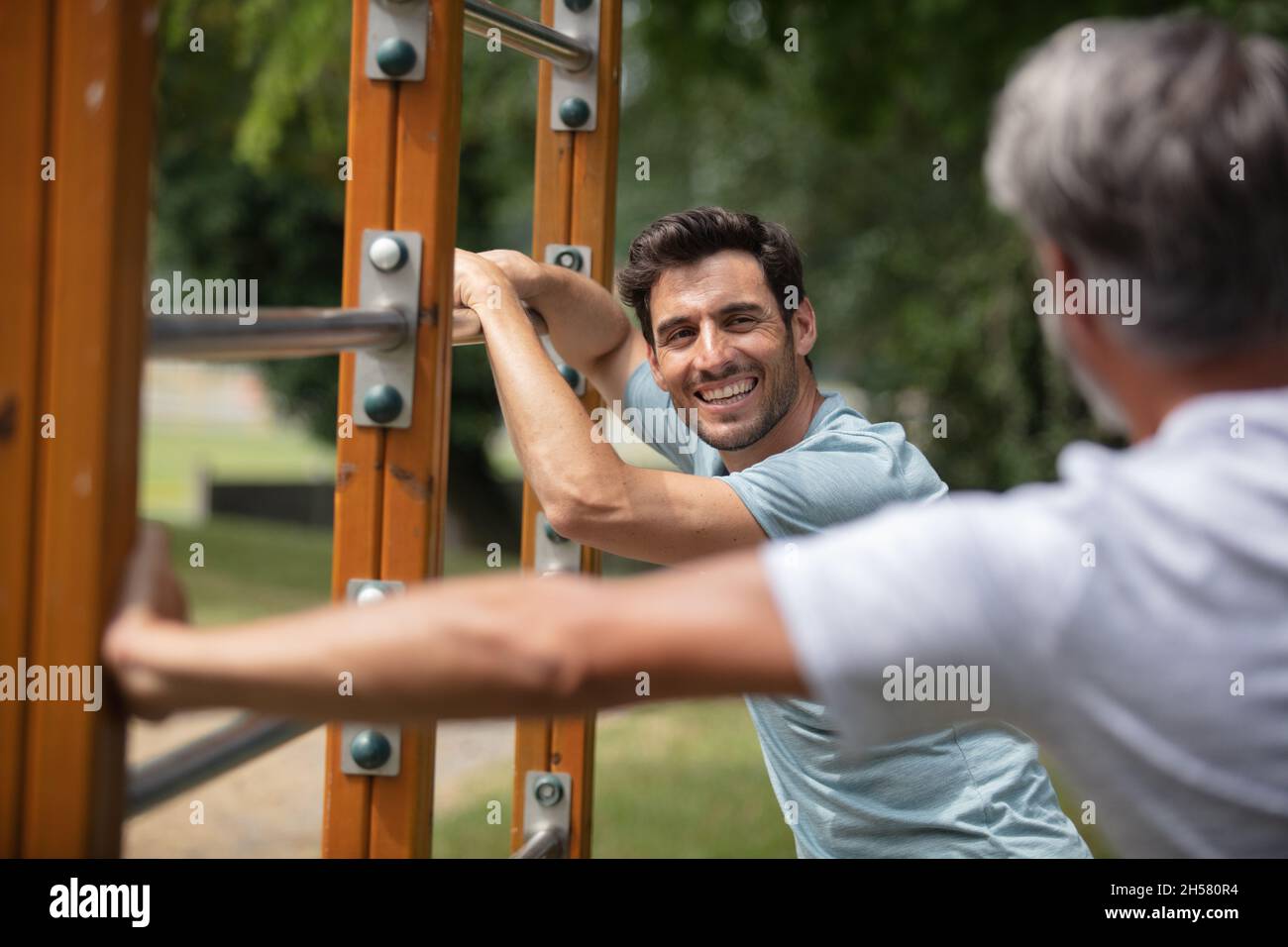 men exercise on outdoor gym in the park Stock Photo - Alamy