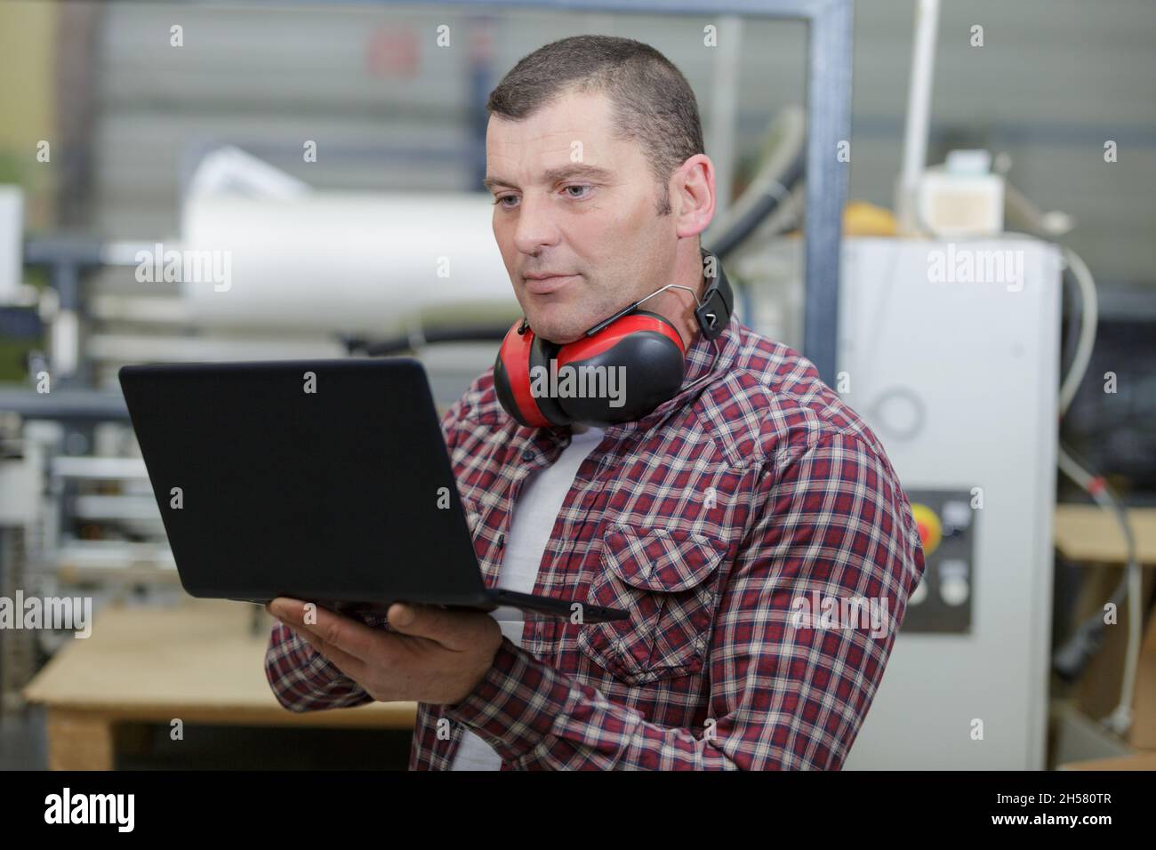 chief engineer in the hard hat holds laptop Stock Photo - Alamy