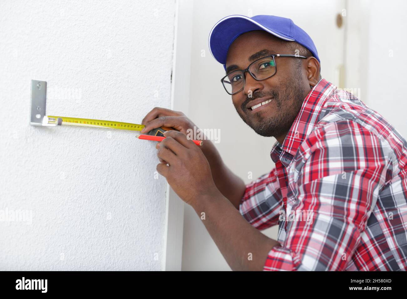 man measuring wall and mark with pen Stock Photo - Alamy