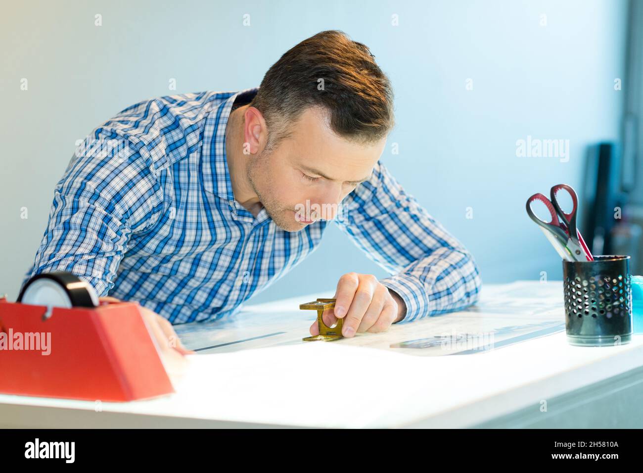 worker uses a magnifying glass in a printing Stock Photo - Alamy