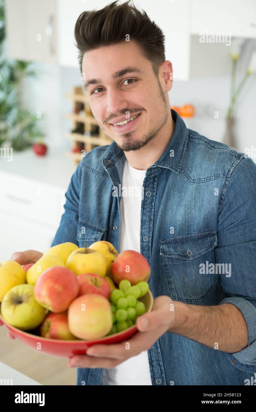 healthy young man holding a bowl of fruit Stock Photo - Alamy