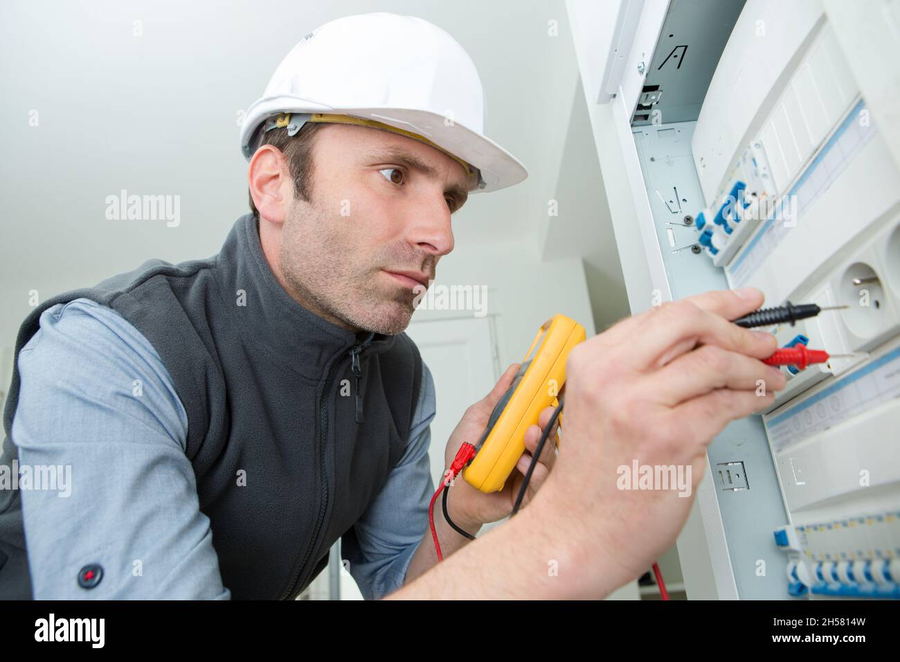 electrician measuring voltage of socket indoors Stock Photo - Alamy