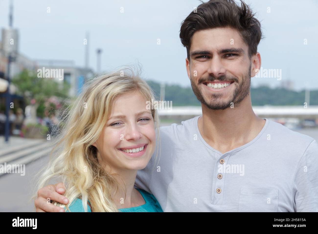 young couple smiling and posing for picture Stock Photo - Alamy
