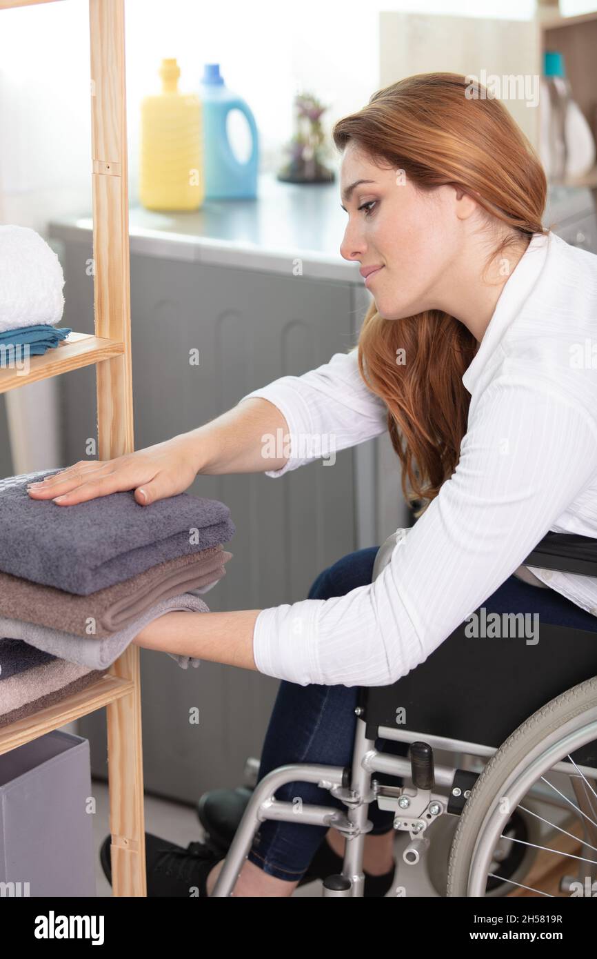happy young disabled woman in wheelchair doing the laundry Stock Photo ...