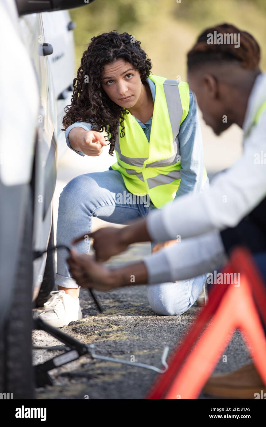 young guy lifting the car on the jack changing wheel Stock Photo - Alamy