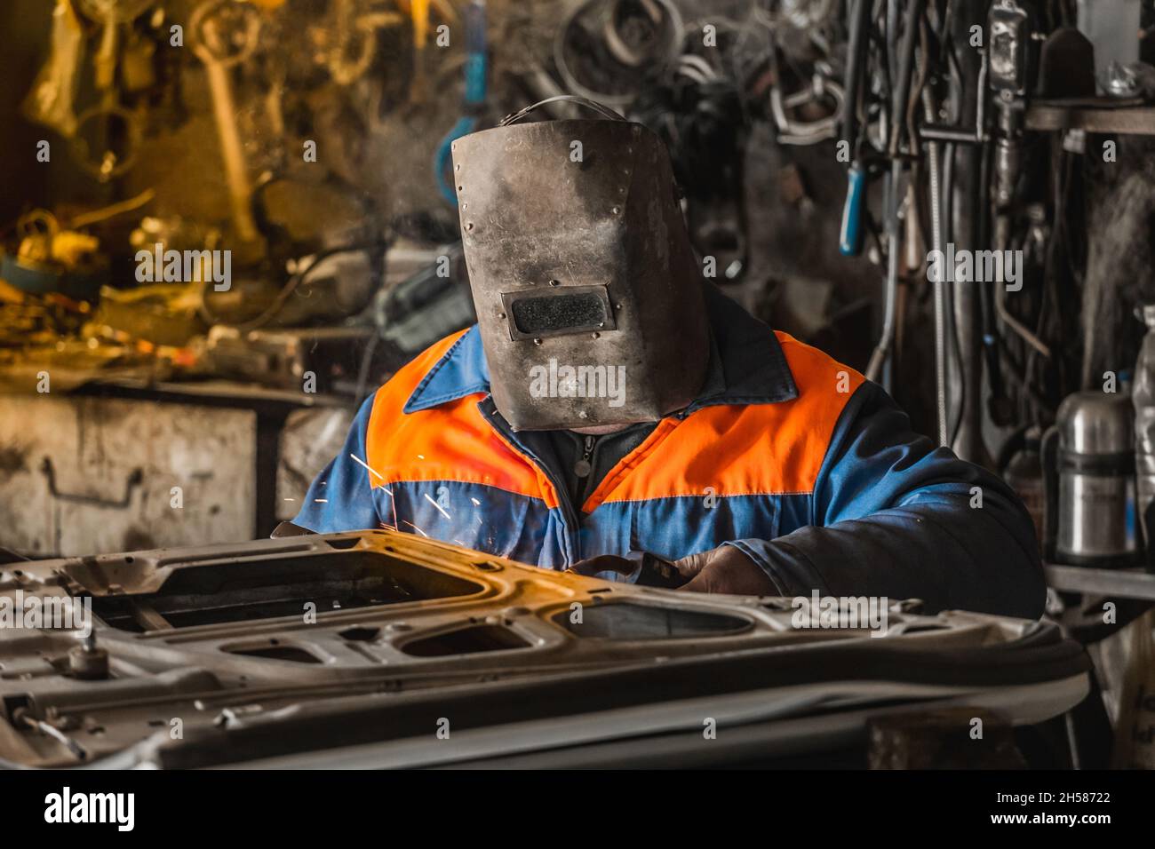 The welder in the protective shield is engaged in welding works and ...