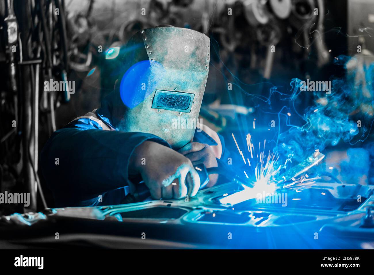 Male welder worker at the plant is engaged in welding and metal work in ...