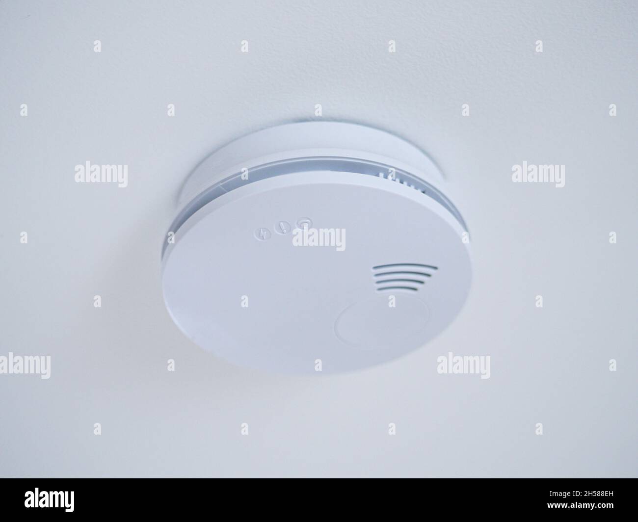 Round white fire sensor or smoke detector on the ceiling. High quality ...