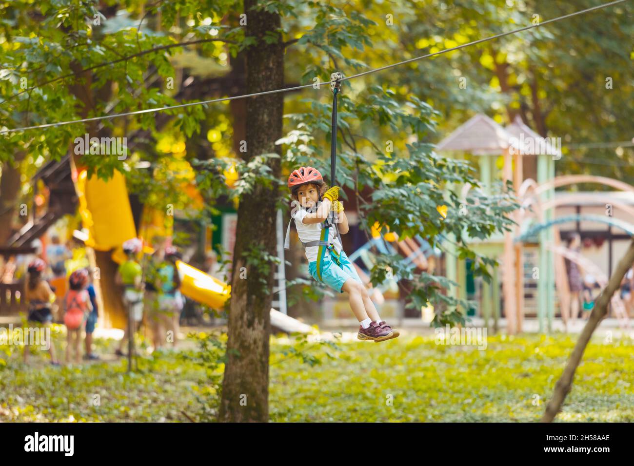 The little boy goes down the zipline in the park Stock Photo - Alamy