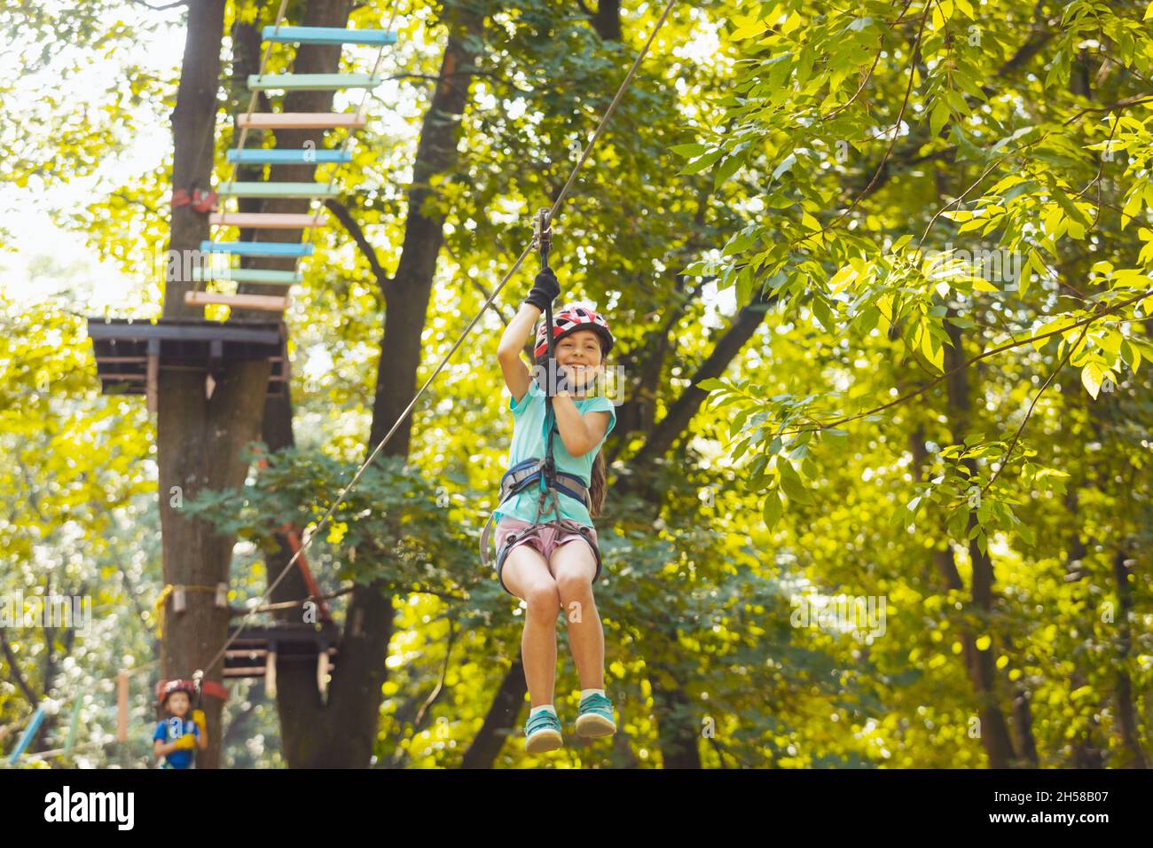 The little boy goes down the zipline in the park Stock Photo - Alamy