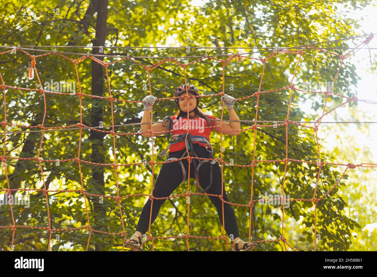 The woman is doing exercise in the adventure rope park Stock Photo - Alamy