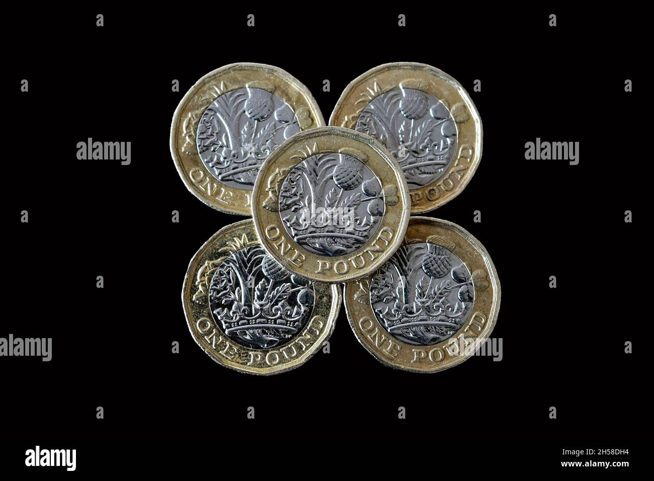 One pound coins isolated against a plain black background. No people ...