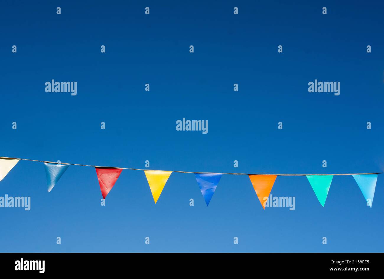 Colorful triangle bunting flags of various colors as festival concep ...