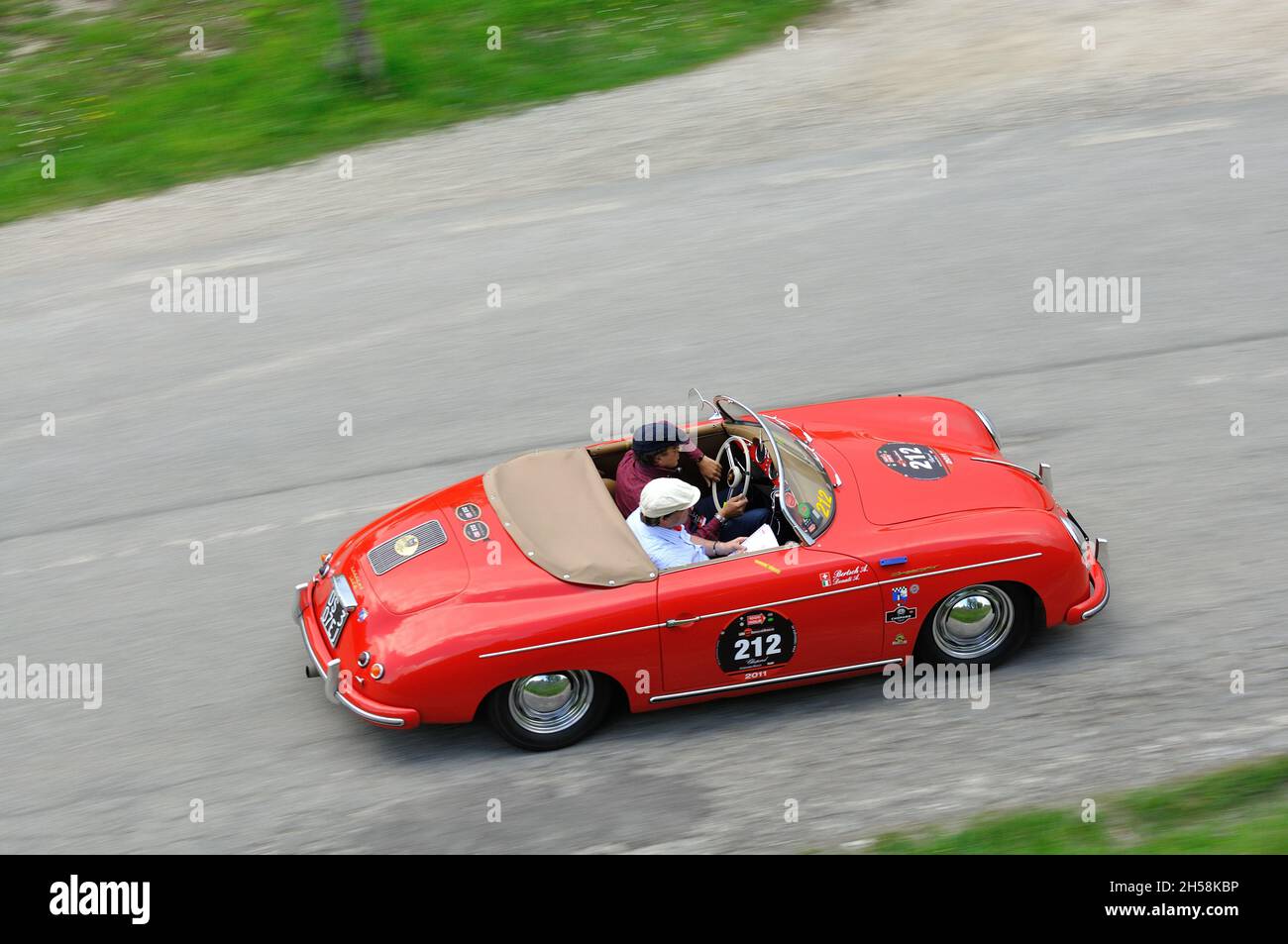 Overhead pan shot of a Porsche 356 Speedster on the Mille Miglia road ...
