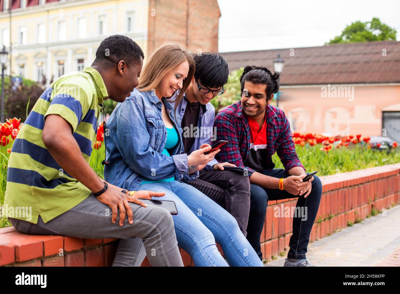 Young girl feeling happy among three multiracial male friends Stock ...