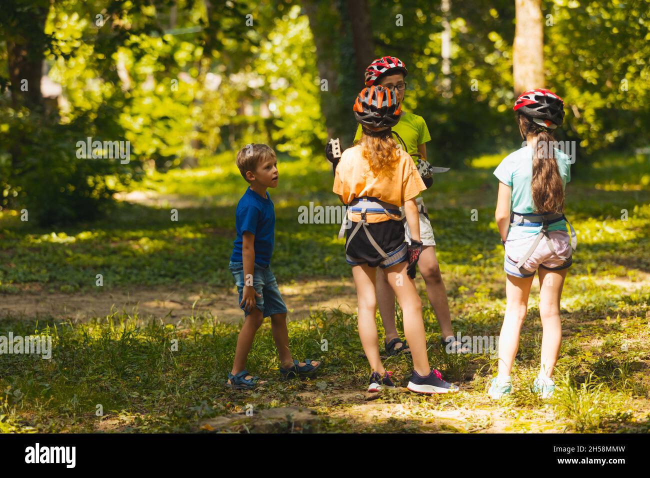 The children are watching their friend in the rope park Stock Photo - Alamy