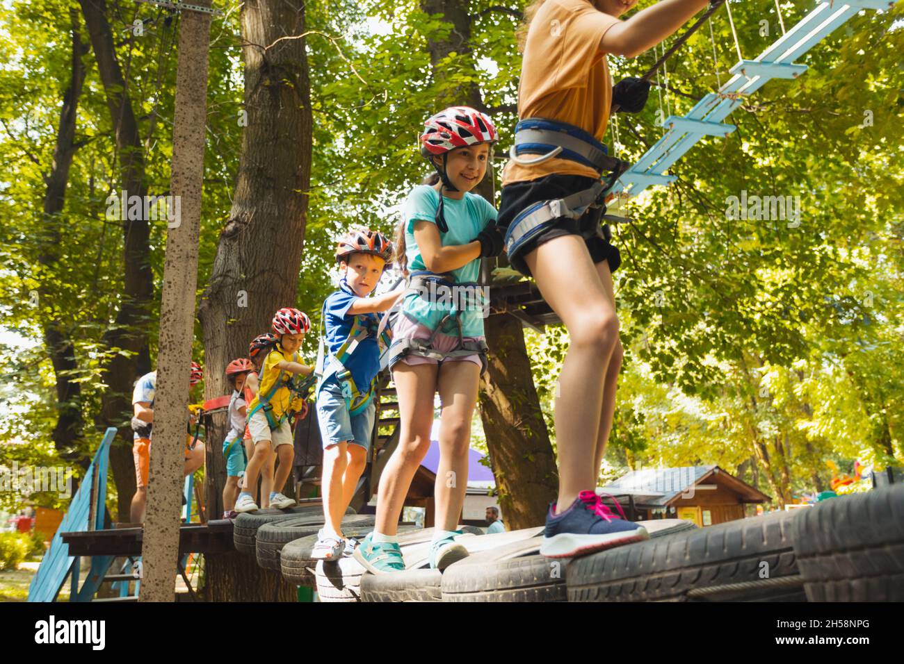The children are overcoming obstacles in the rope park Stock Photo - Alamy