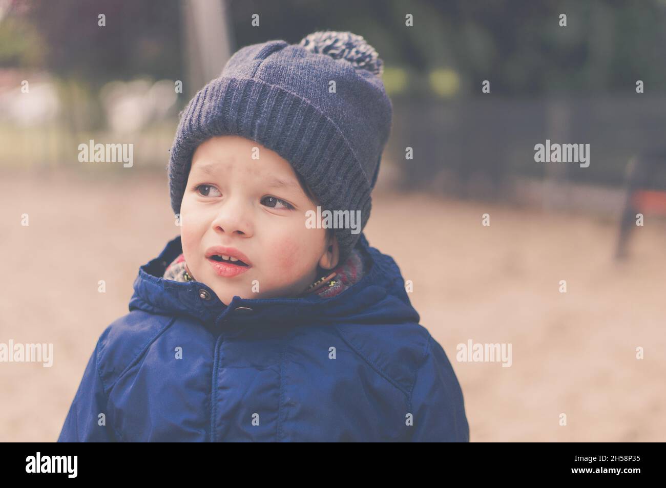 A portrait of a caucasian little boy with a curious facial expression ...