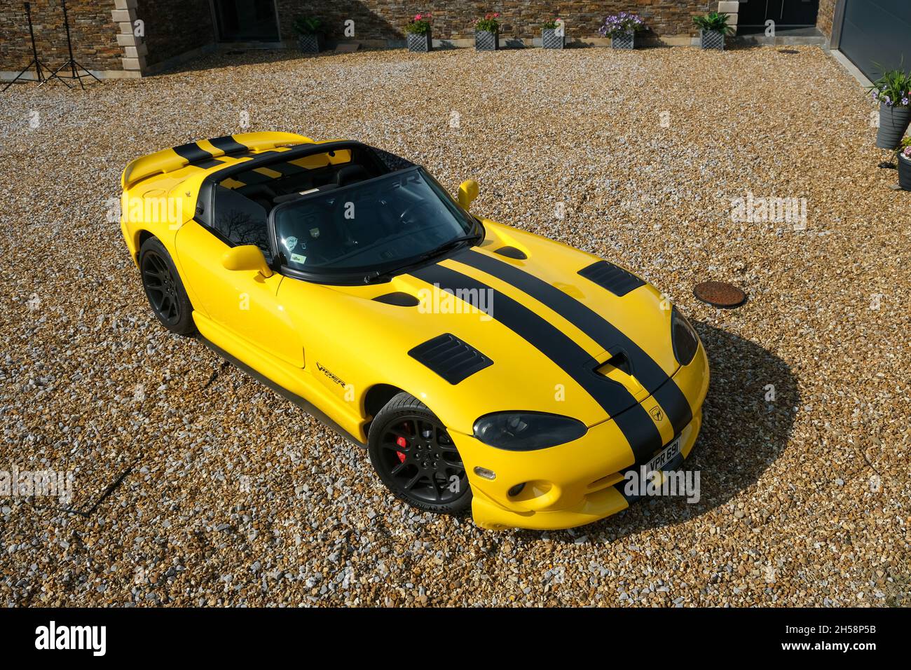 Yellow Dodge Viper SRT 10 parked on a gravel forcourt in front of a ...