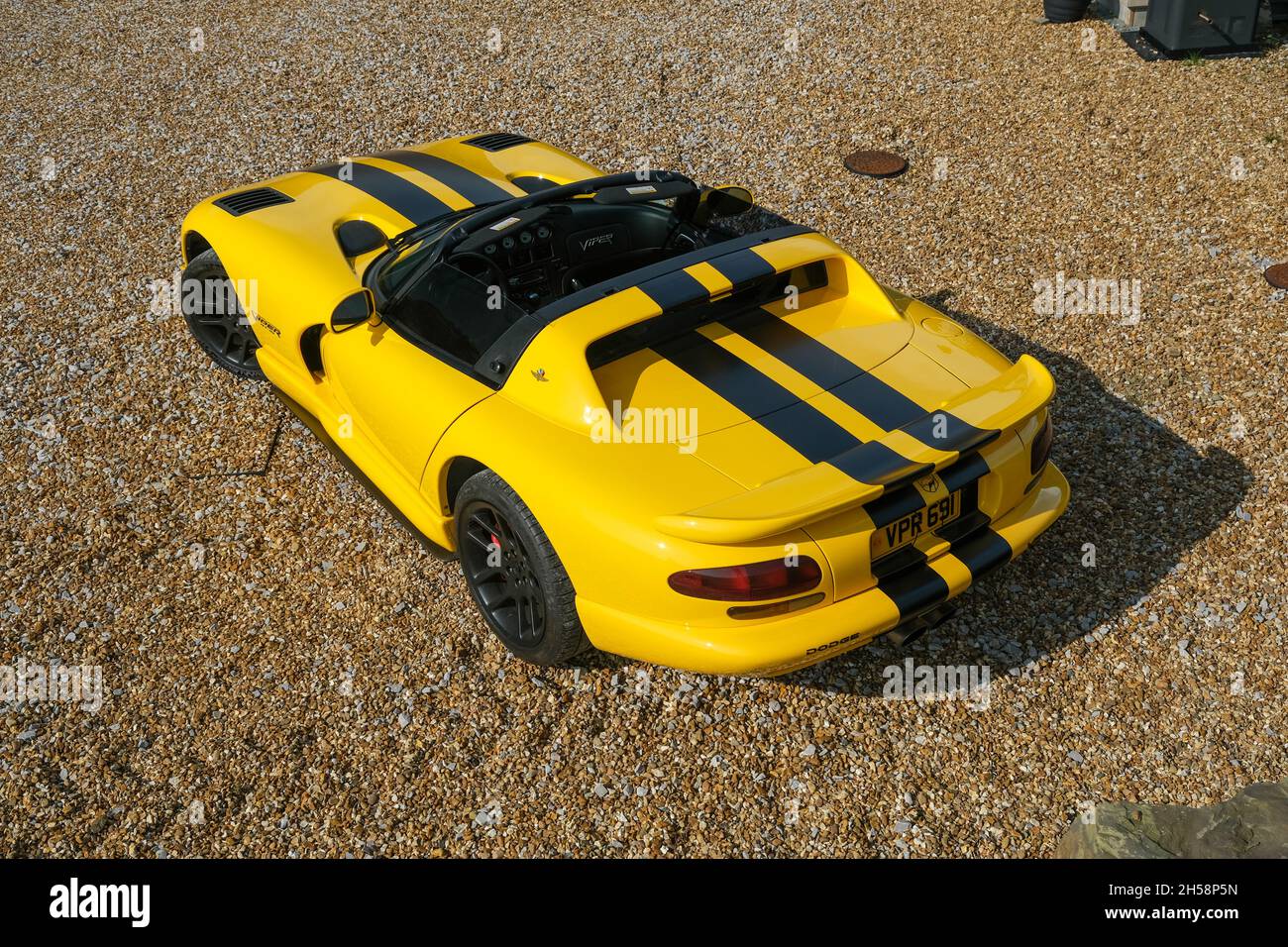 Yellow Dodge Viper SRT 10 parked on a gravel forcourt in front of a ...