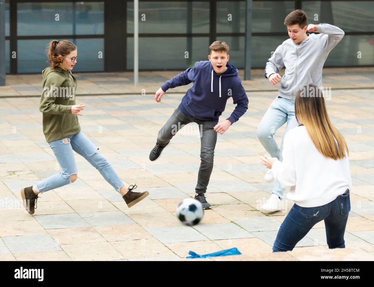 Teenagers play street football with excitement on street Stock Photo ...