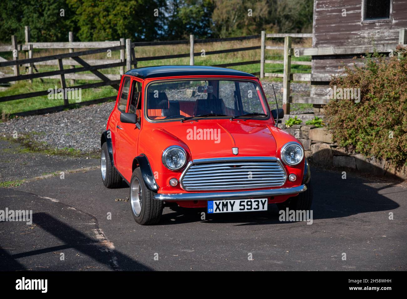 classic Austin Mini parked on a gravel drive in a rural farm setting ...