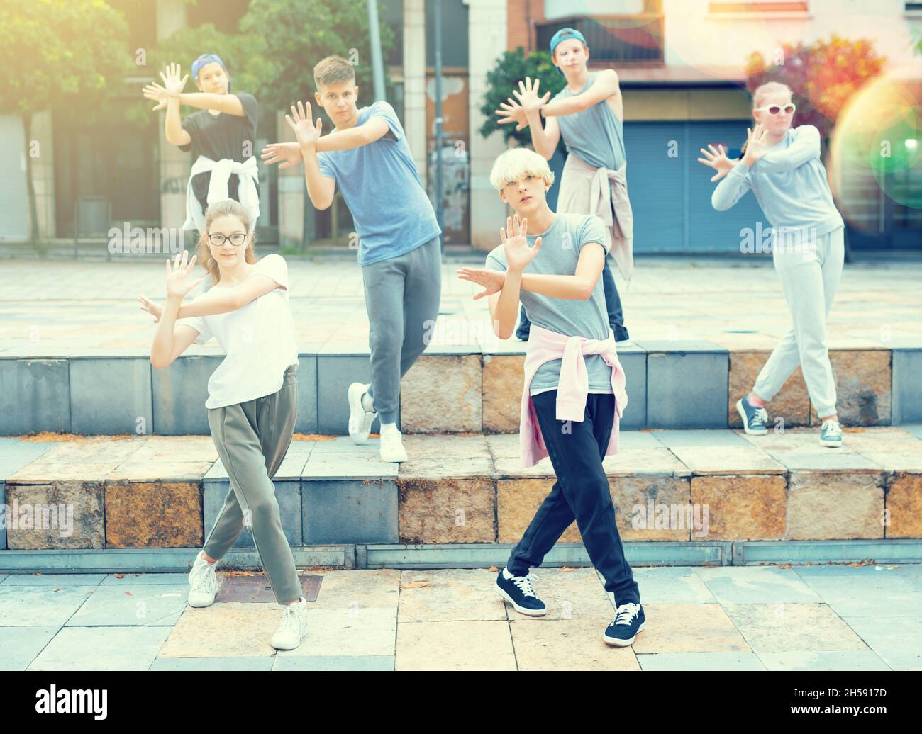 Teen boys and girls dancing modern choreography on city street Stock ...