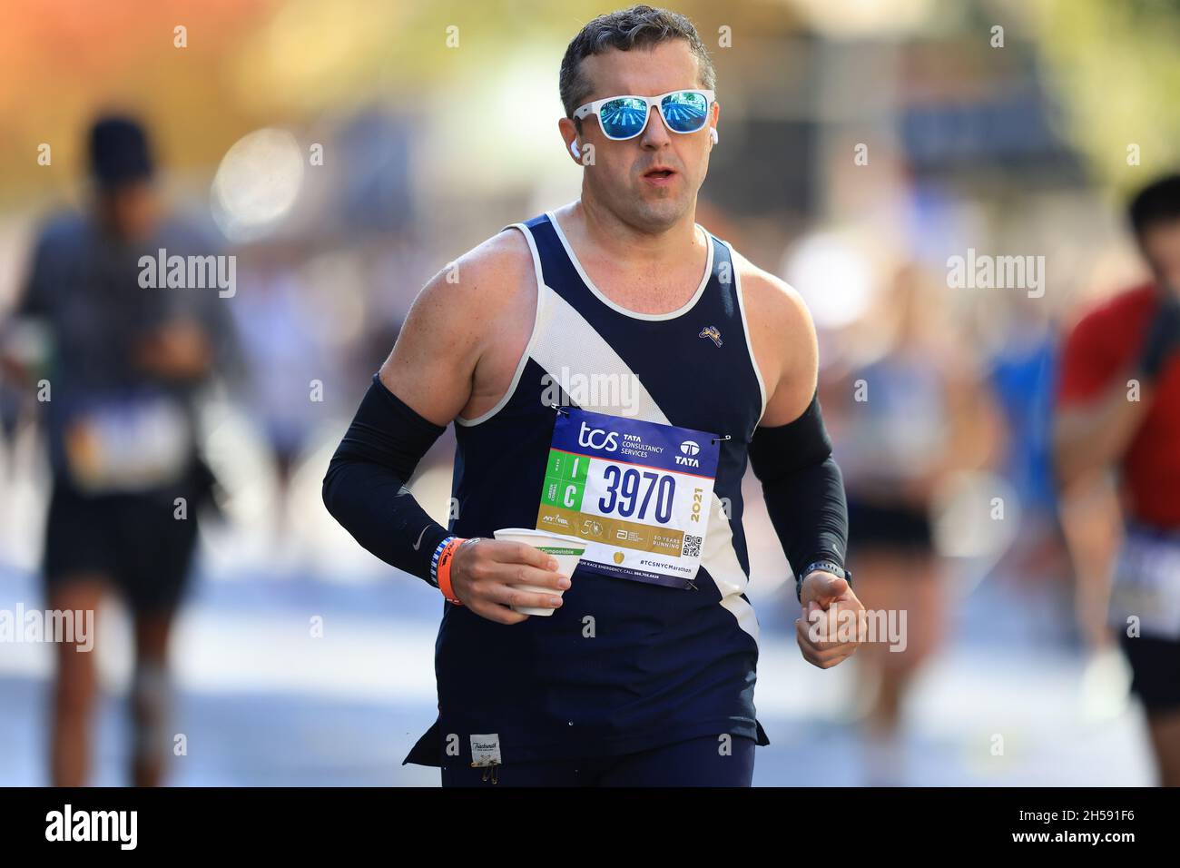 New York, N.Y/USA – 7th Nov. 2021: A marathoner runs with a cup of ...